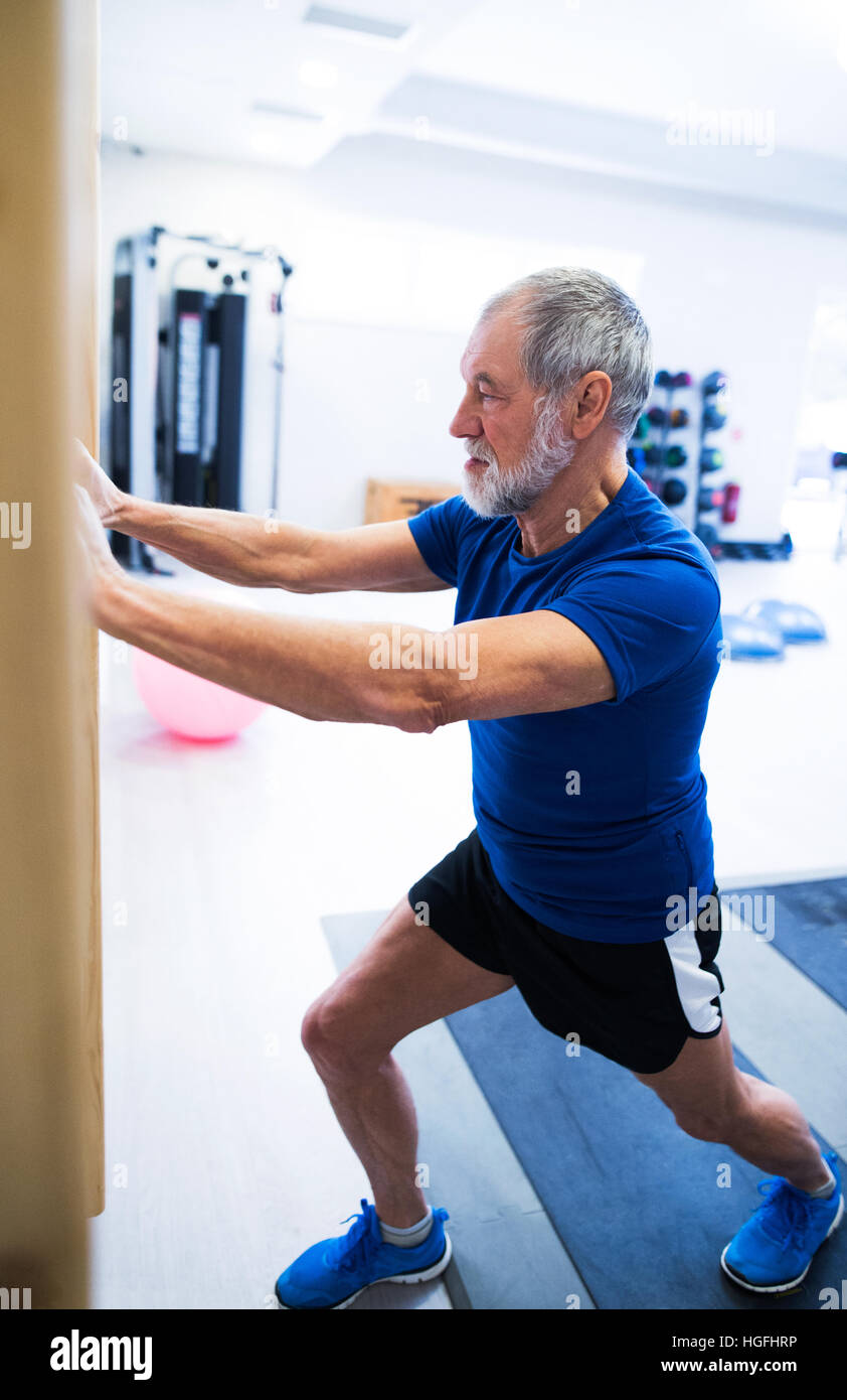 Senior man in gym working out, stretching his legs Stock Photo - Alamy