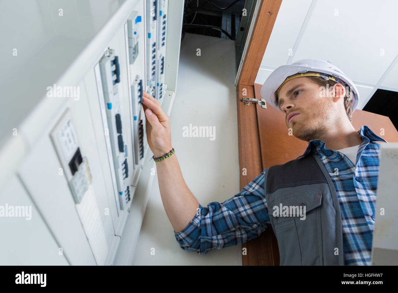 young electrician working on electric panel Stock Photo - Alamy