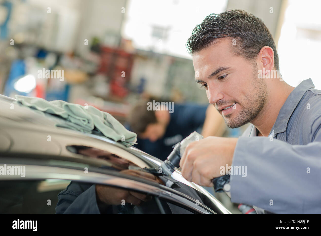 Man buffing roof of car with machine Stock Photo - Alamy