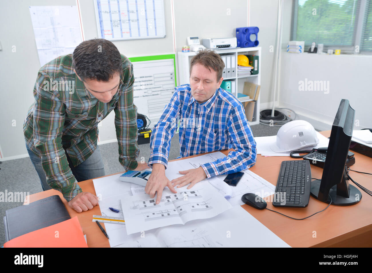 Employees examining a layout Stock Photo - Alamy