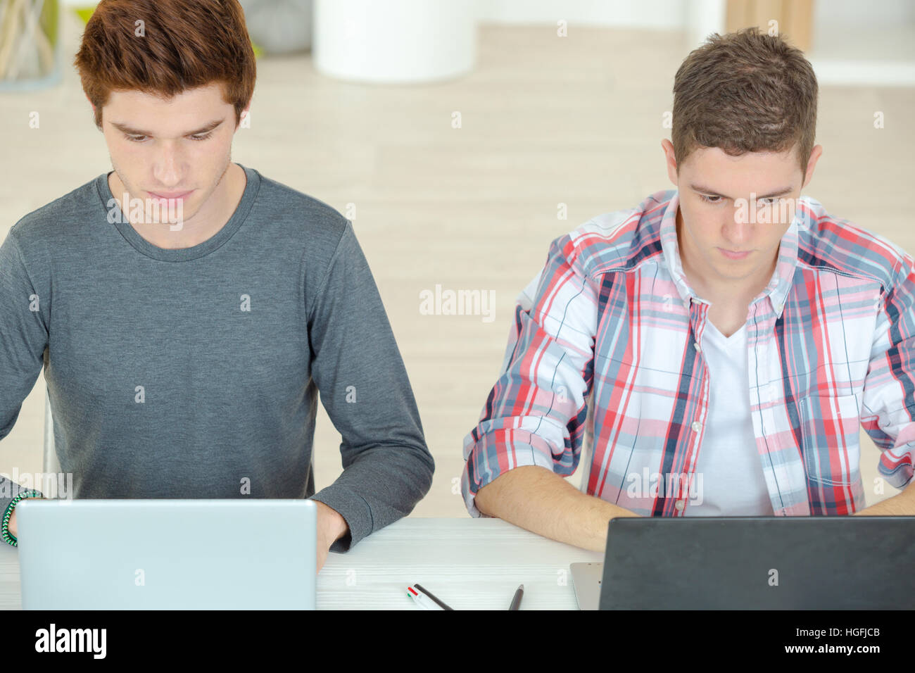 Two male students using laptops Stock Photo - Alamy