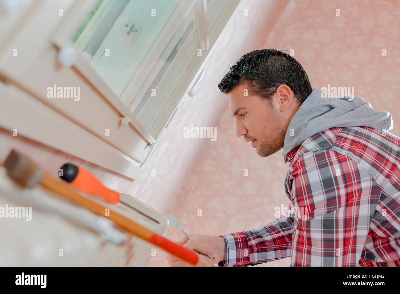 Plumber fixing a radiator Stock Photo - Alamy