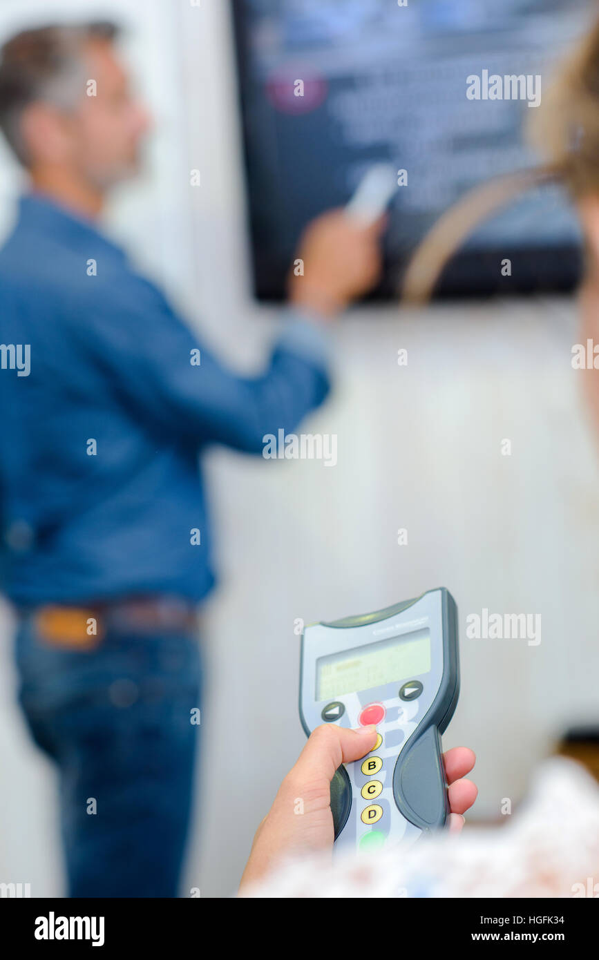 Woman using electronic device for a multiple choice question on screen ...