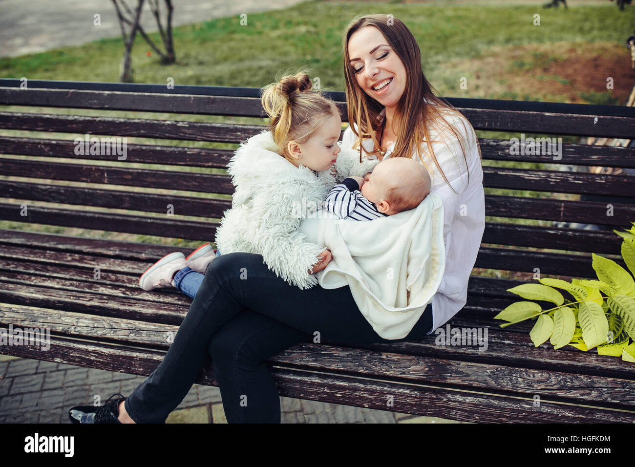 mother and two daughters rest on a bench Stock Photo - Alamy