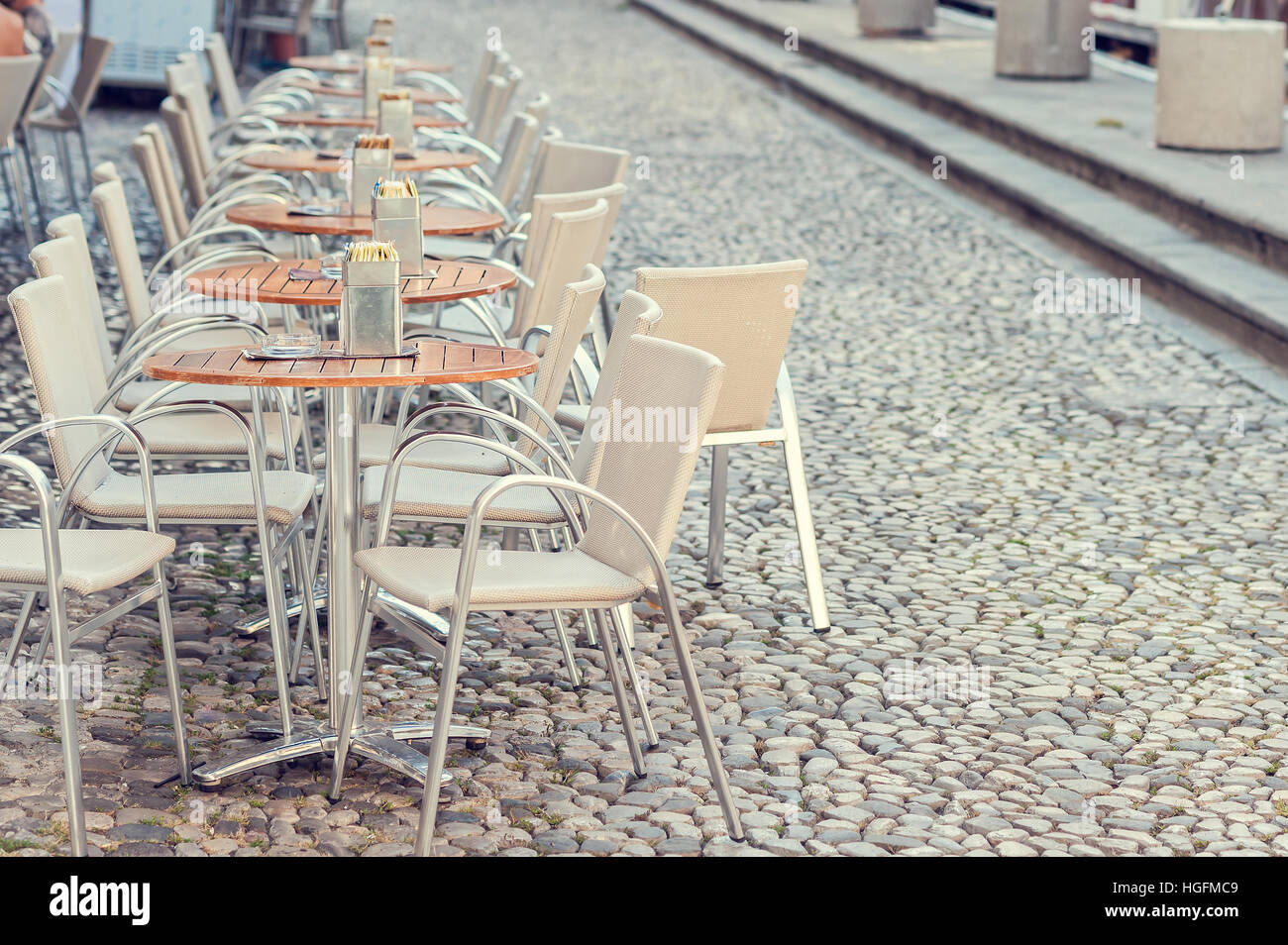 A row of small tables of a café on a pedestrian street Stock Photo - Alamy