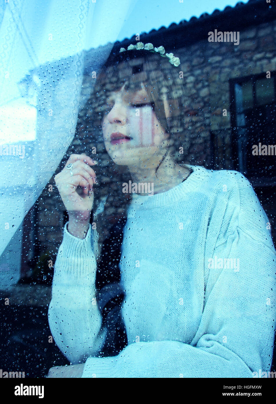 Portrait of a young woman in a rainy day through a window Stock Photo ...