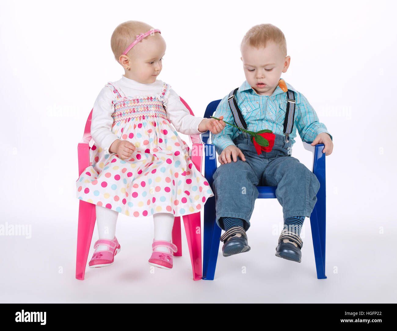 funny boy and girl sitting on chairs on white Stock Photo - Alamy