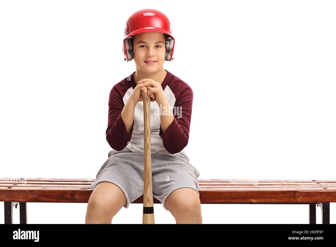 Boy with a helmet and a baseball bat sitting on a bench isolated on ...