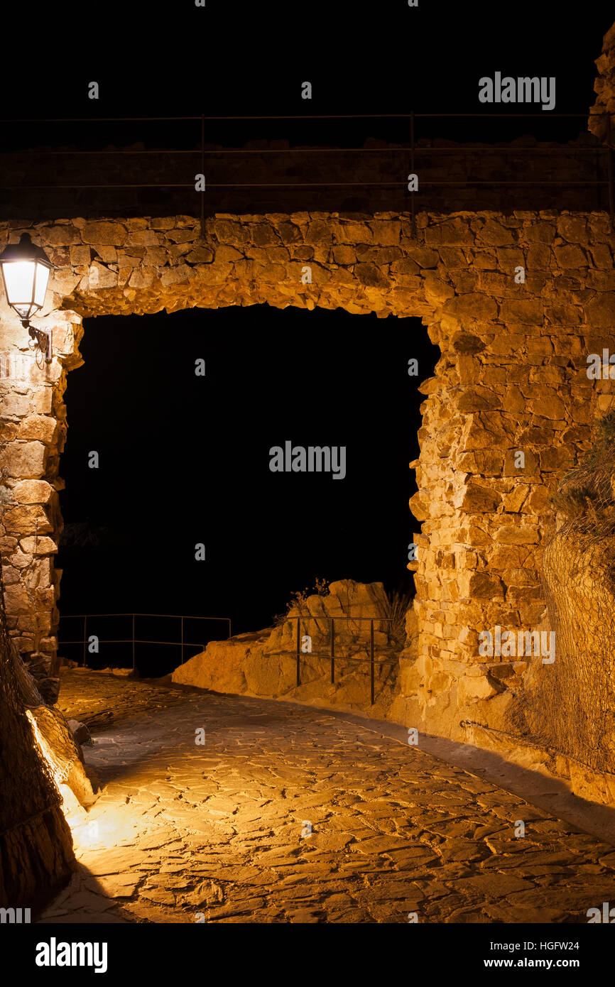 Stone wall with gate illuminated at night, medieval fortification of ...