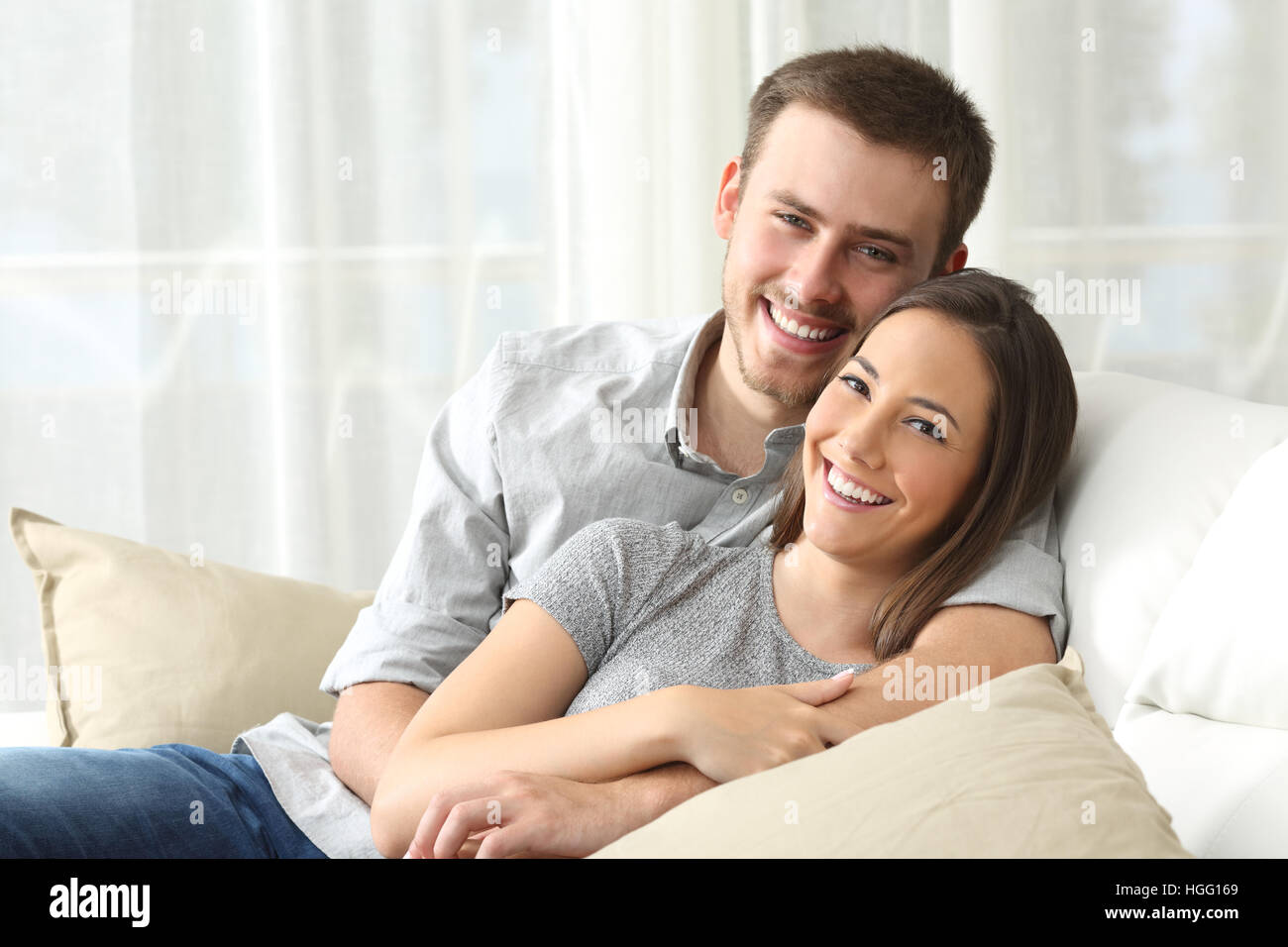 Happy couple sitting in a comfortable couch in the living room and ...