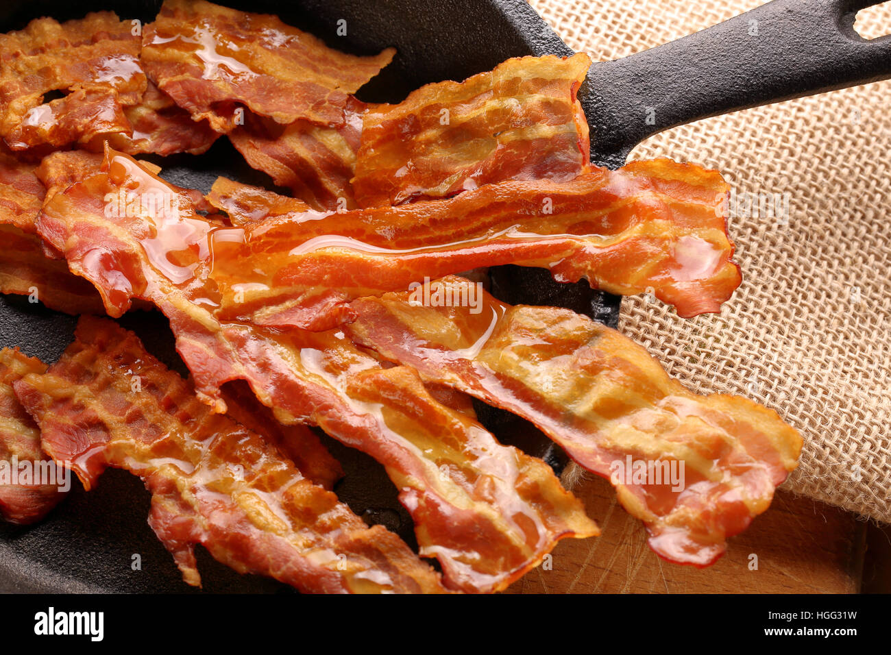 Hot fried bacon pieces in a cast iron skillet Stock Photo - Alamy