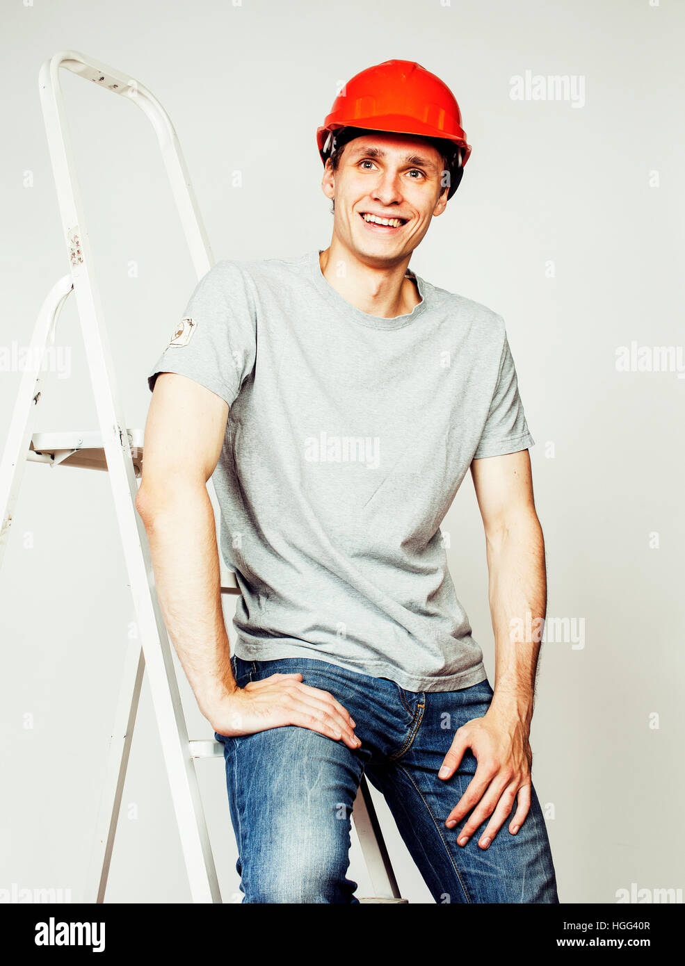 young real hard worker man isolated on white background on ladder ...
