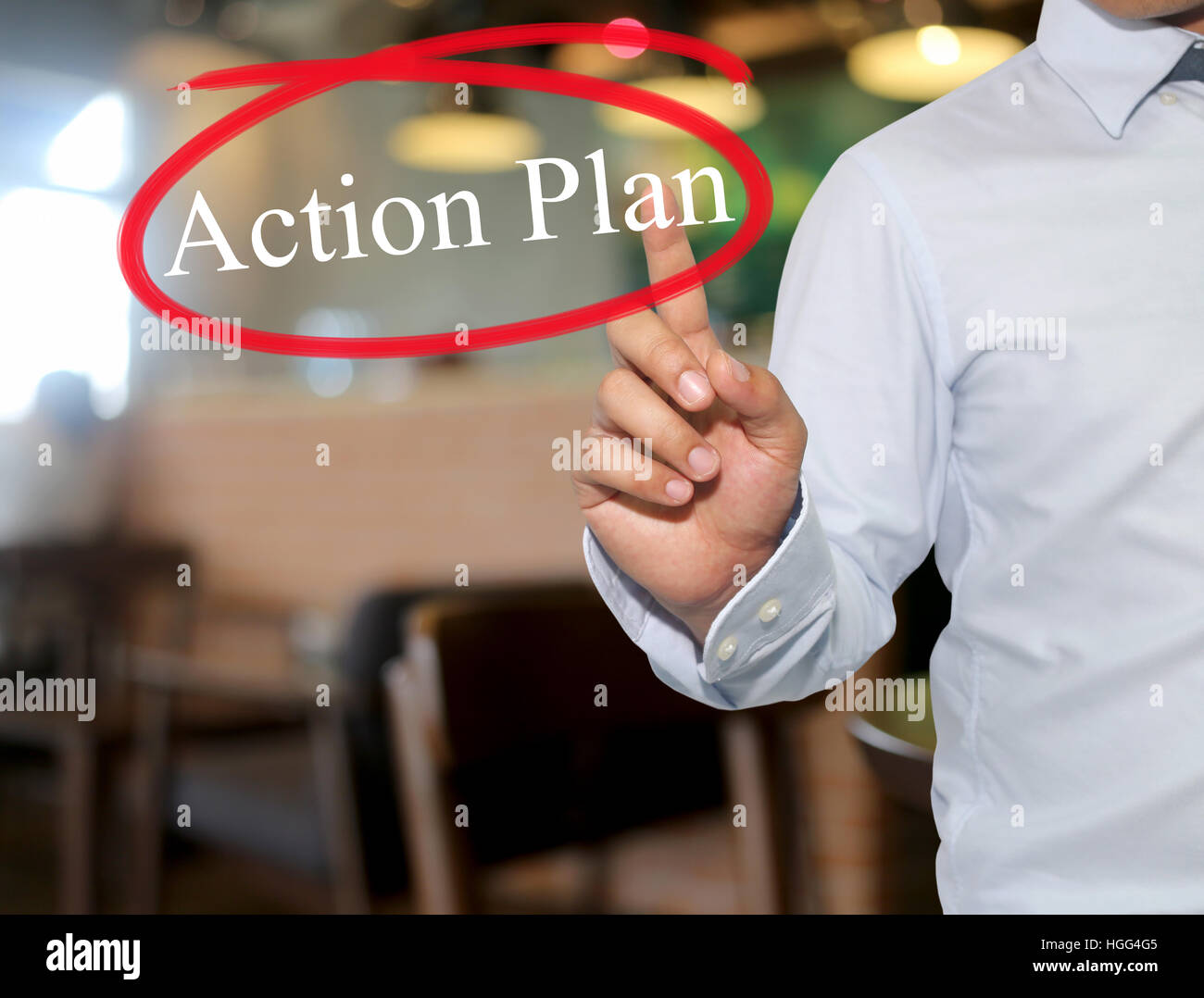 Hand of man touching text Action Plan with white color on blur interior ...