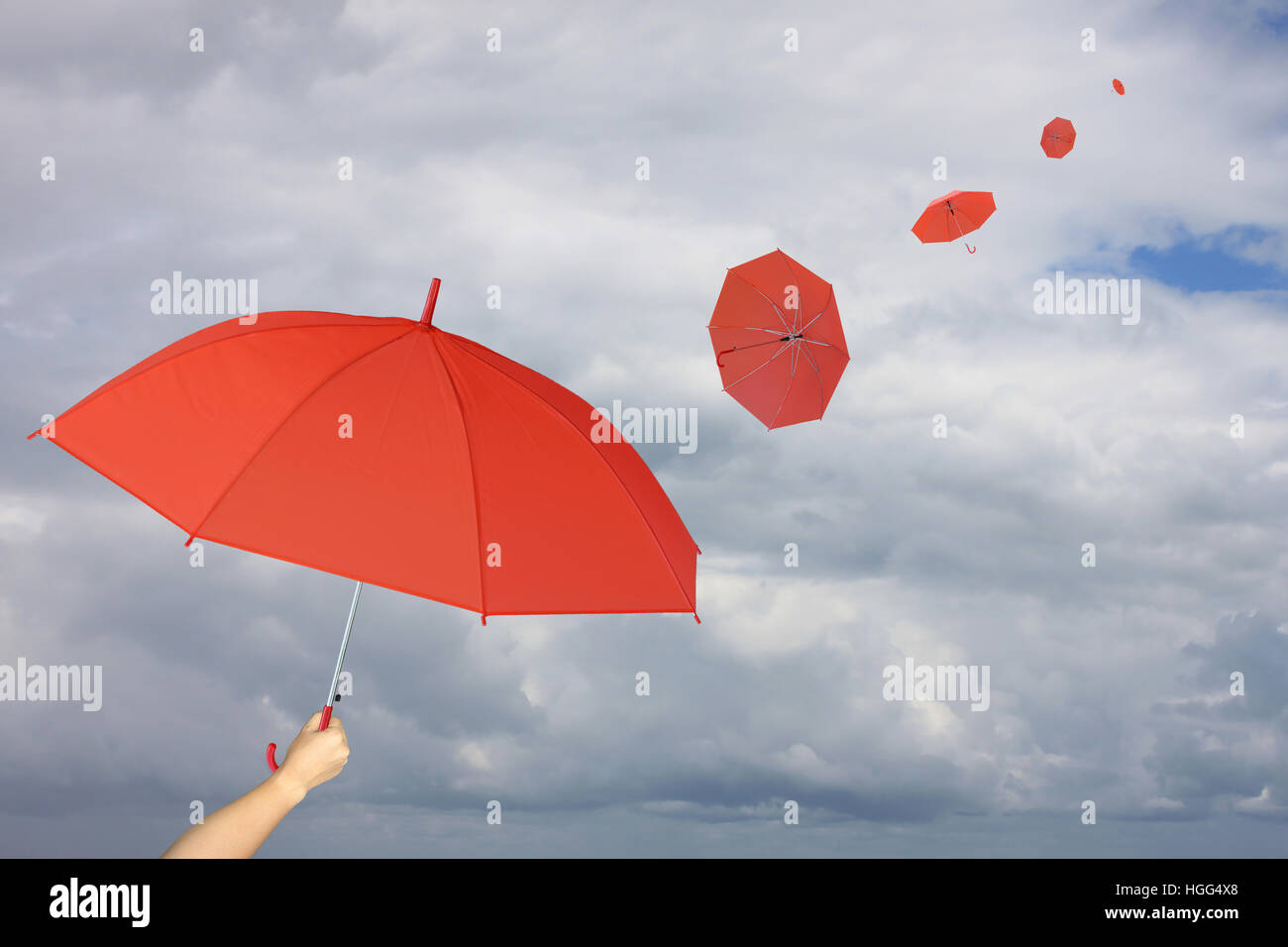 Red umbrella in hand and umbrella other blown by wind,concept for ...