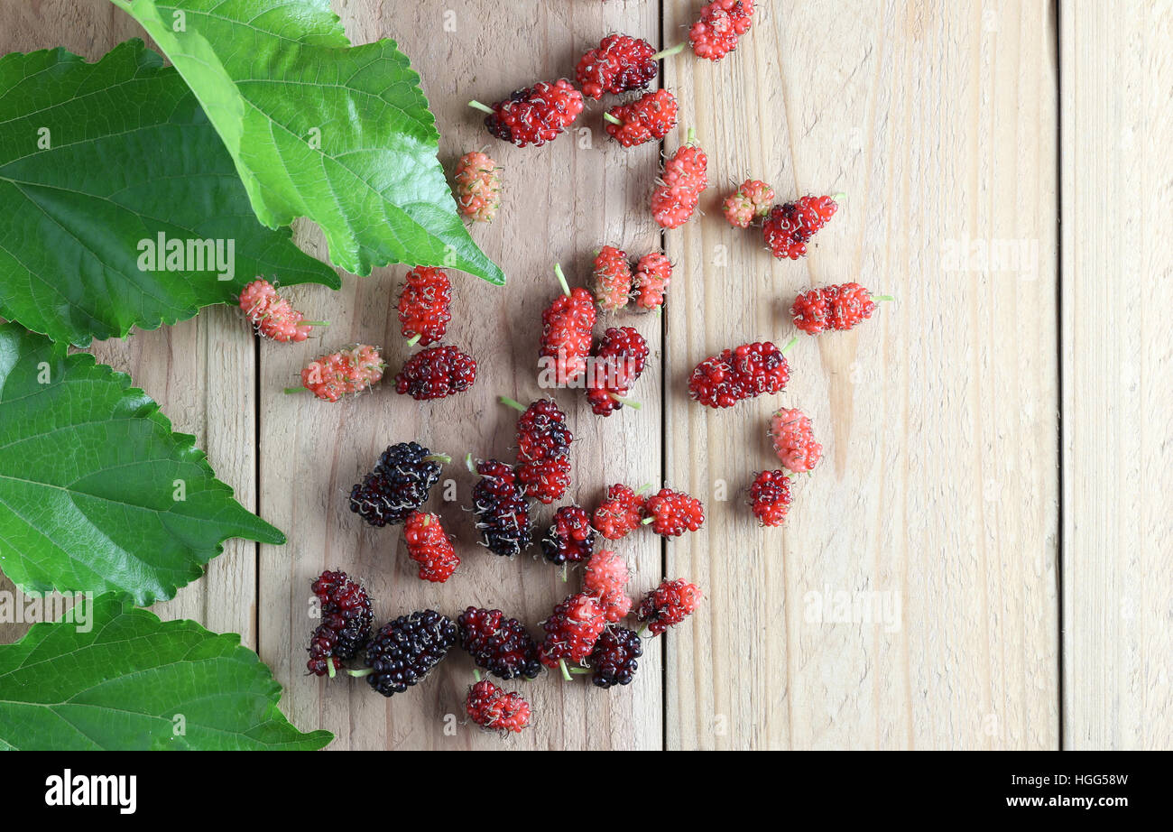 Mulberry fruit and green leaves on wood background,concept of healthy ...