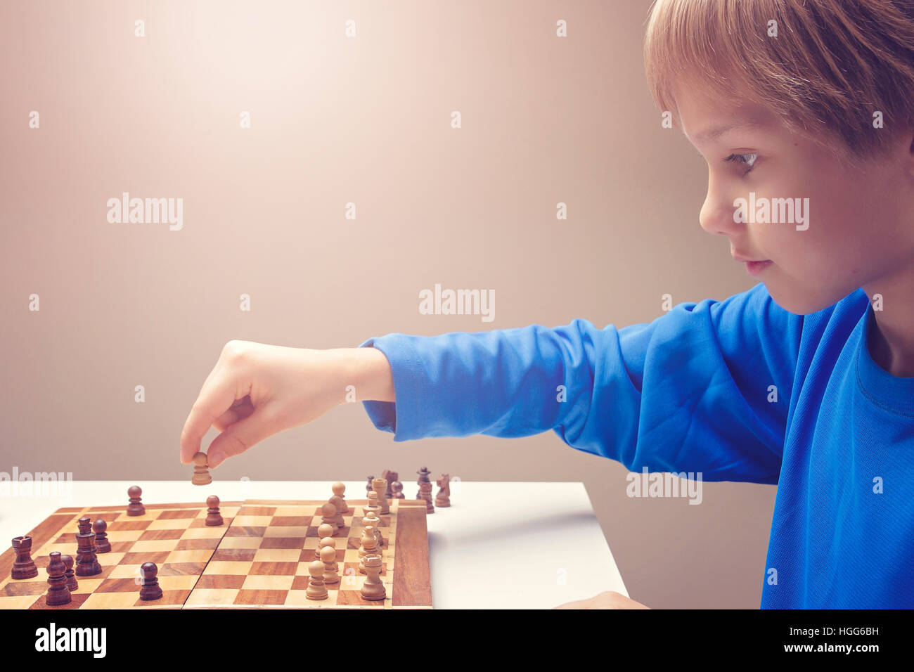 Portrait of a little caucasian boy playing chess Stock Photo - Alamy