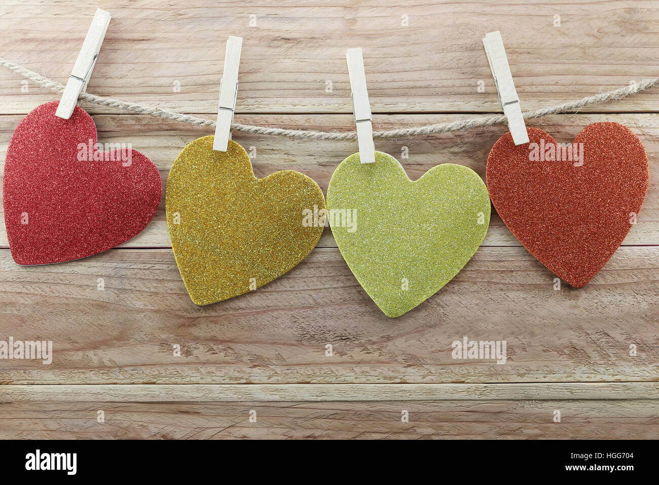 Paper Heart shape hanging on a hemp rope on brown wood background ...
