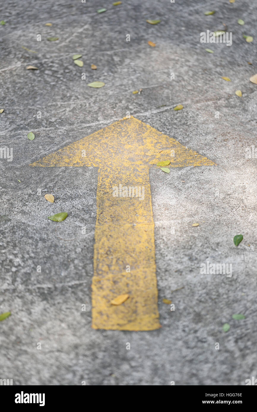 Symbol of old yellow arrows on the pavement in signal that a straight ...