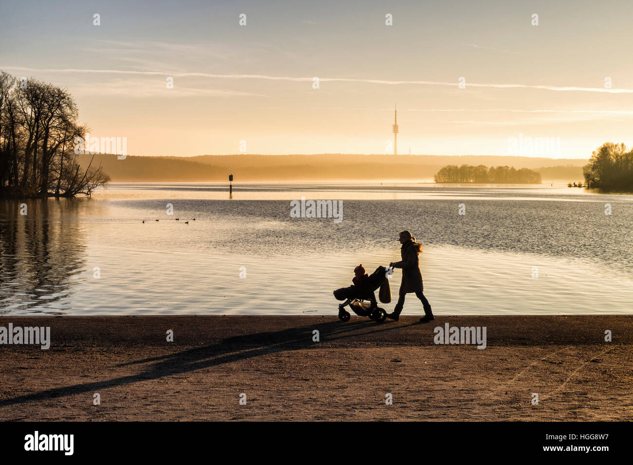 Kladow, Berlin. Young woman pushing pram in golden light next to Havel ...
