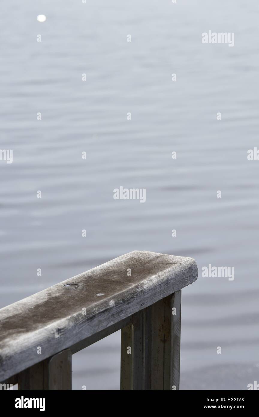 Wooden railing with bright water ripples in the background Stock Photo ...