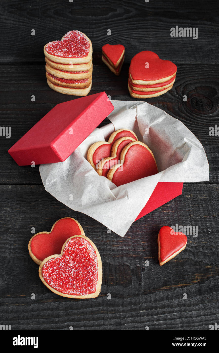 Red cookies with red icing and box on the old brown wooden table Stock ...