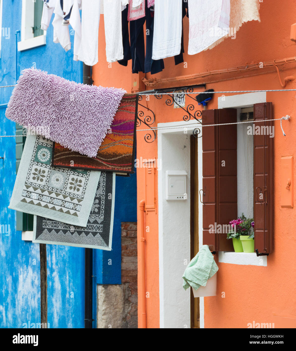 Washing including rugs hanging on the line outside houses on Burano ...