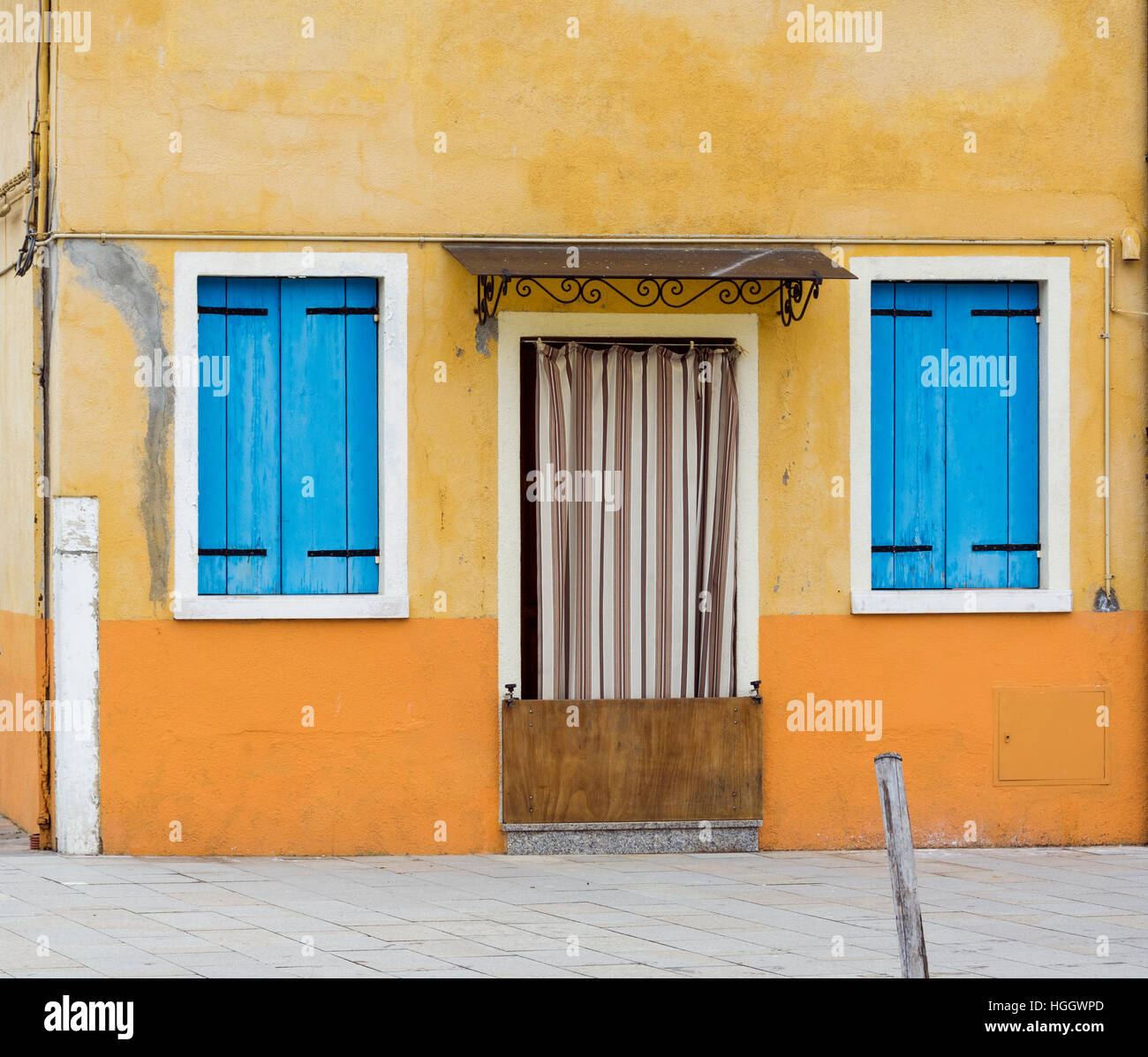 Pretty yellow house with blue shutters in Burano, Venice, Italy Stock ...