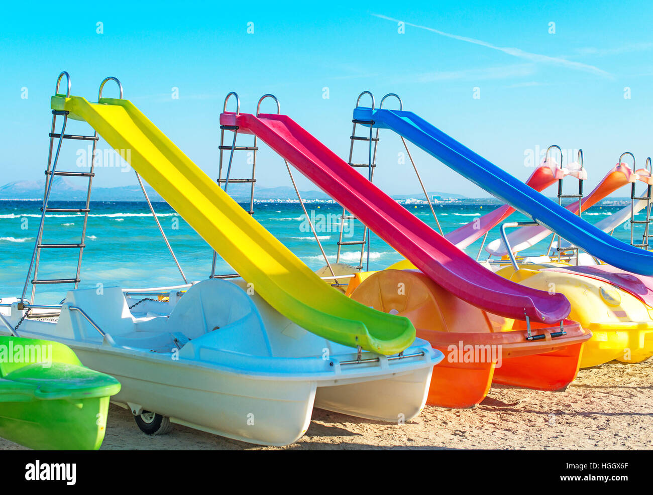 Pedal-boats with water slides on the beach Stock Photo - Alamy