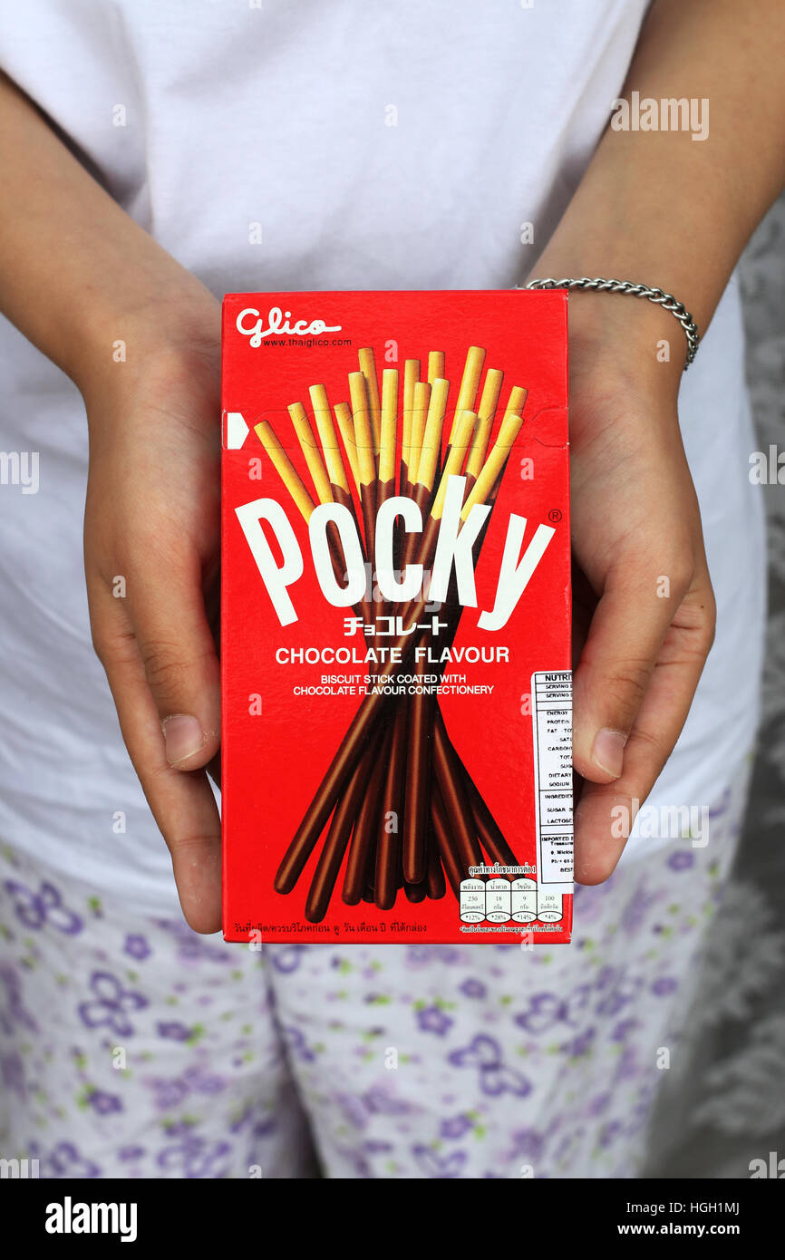 Close up of a child holding Pocky Chocolate flavour covered biscuit ...
