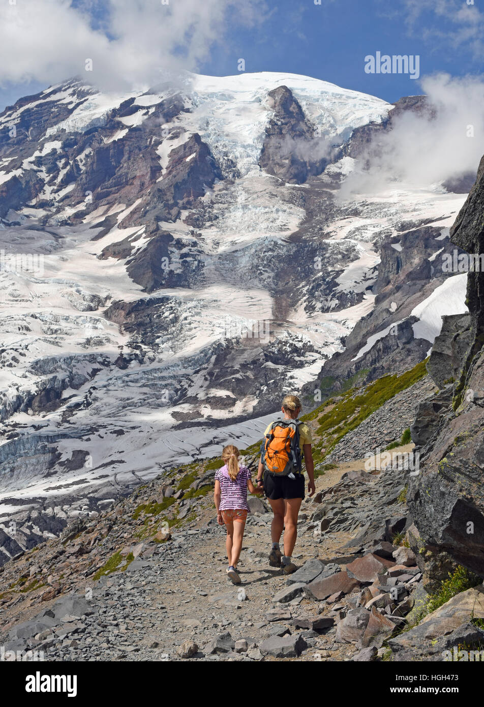 Hikers on skyline trail in front of snow capped Mount Rainier, Paradise ...