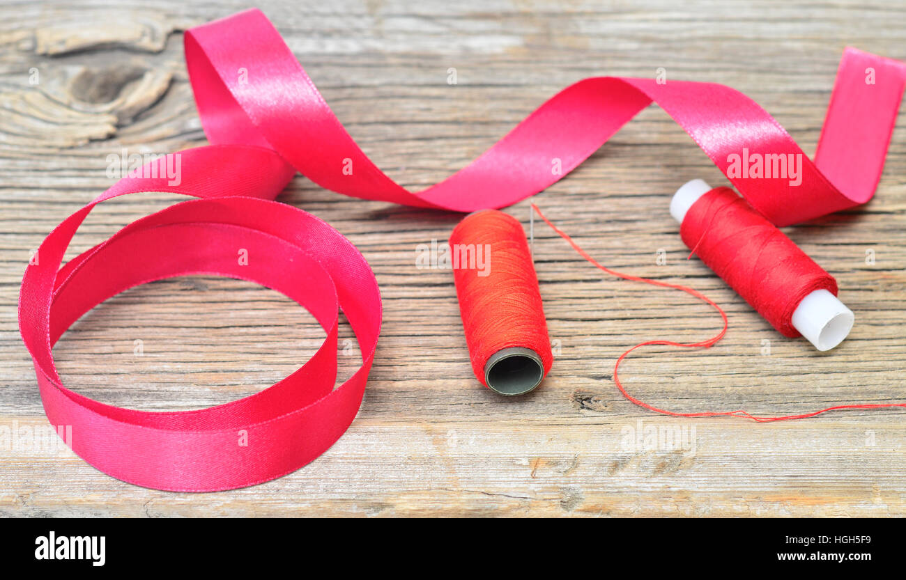 thread with ribbon on an old wooden surface Stock Photo - Alamy