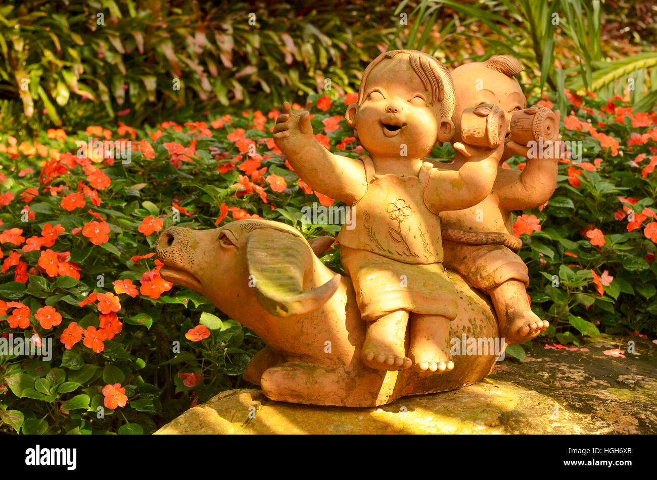boy and girl statue in park on a background of flowers Stock Photo - Alamy