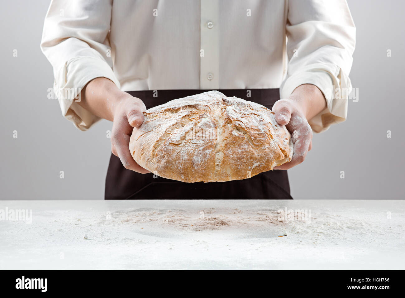 Baker man holding rustic organic loaf of bread in hands Stock Photo - Alamy