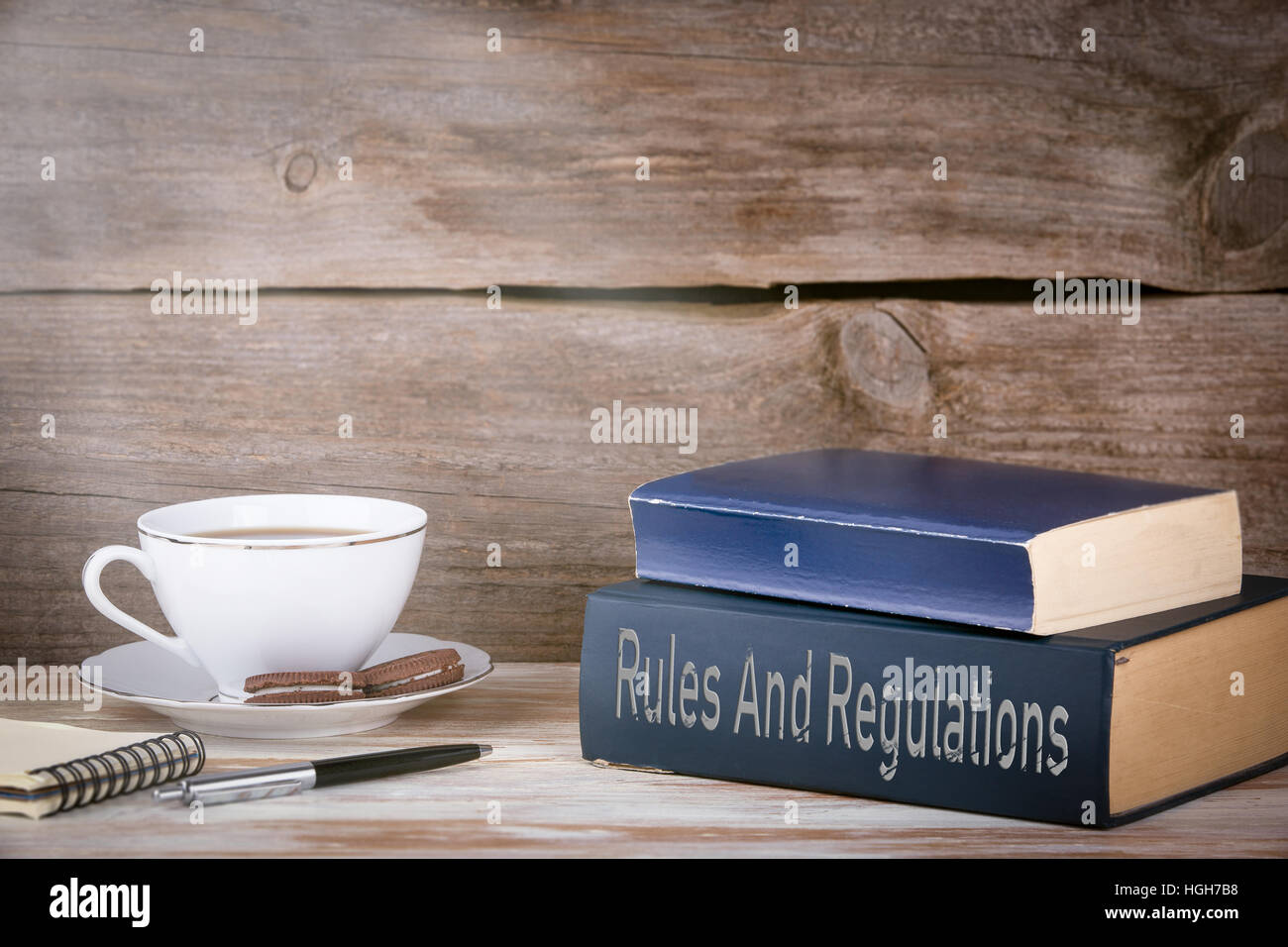 Rules And Regulations. Stack of books on wooden desk Stock Photo - Alamy