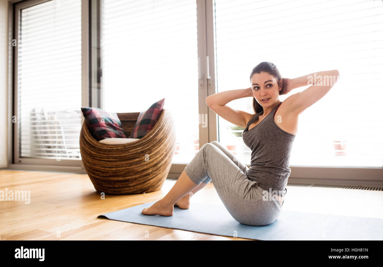 Young woman exercising at home, doing crunches Stock Photo - Alamy