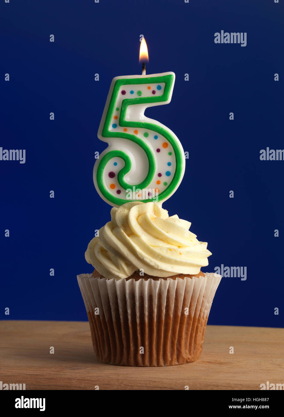 Cupcake with a number five candle with a Blue Background Stock Photo ...
