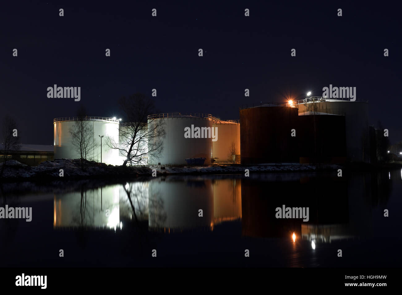 Oil tanks in the night reflecting in water, picture from the North of ...