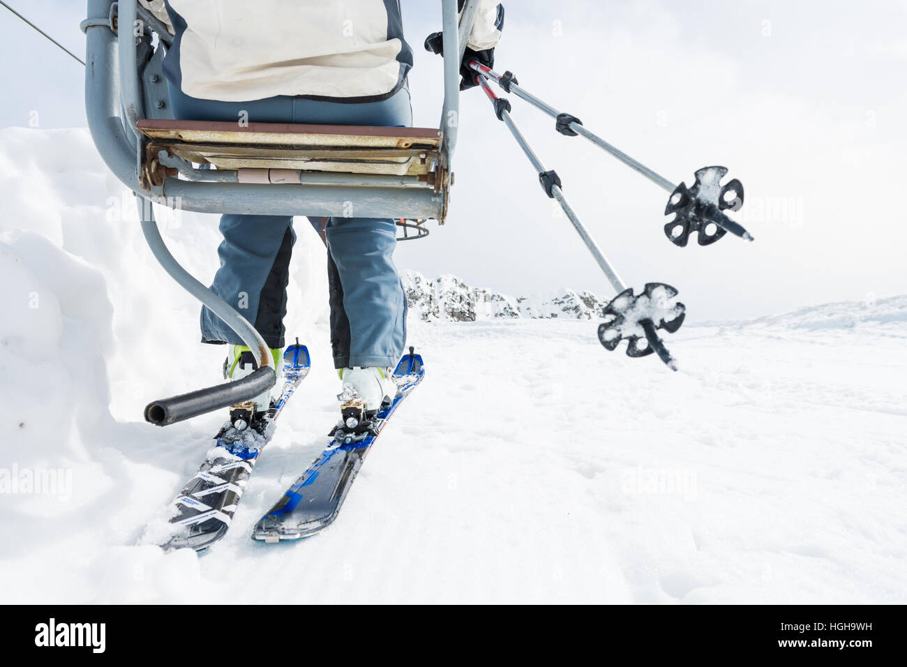 Back view of skier riding a lift Stock Photo - Alamy