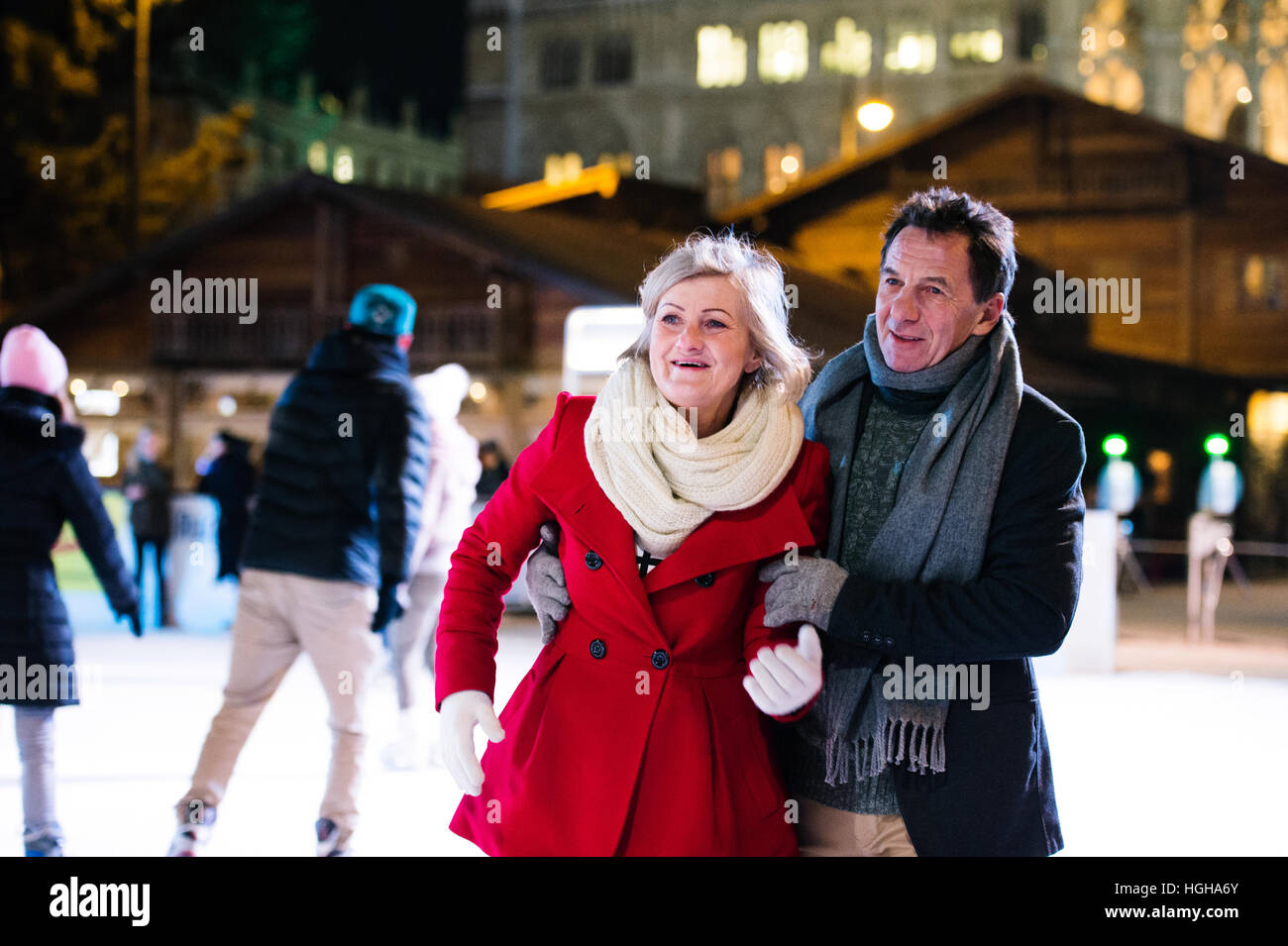 Beautiful senior couple ice skating in city centre. Winter Stock Photo ...