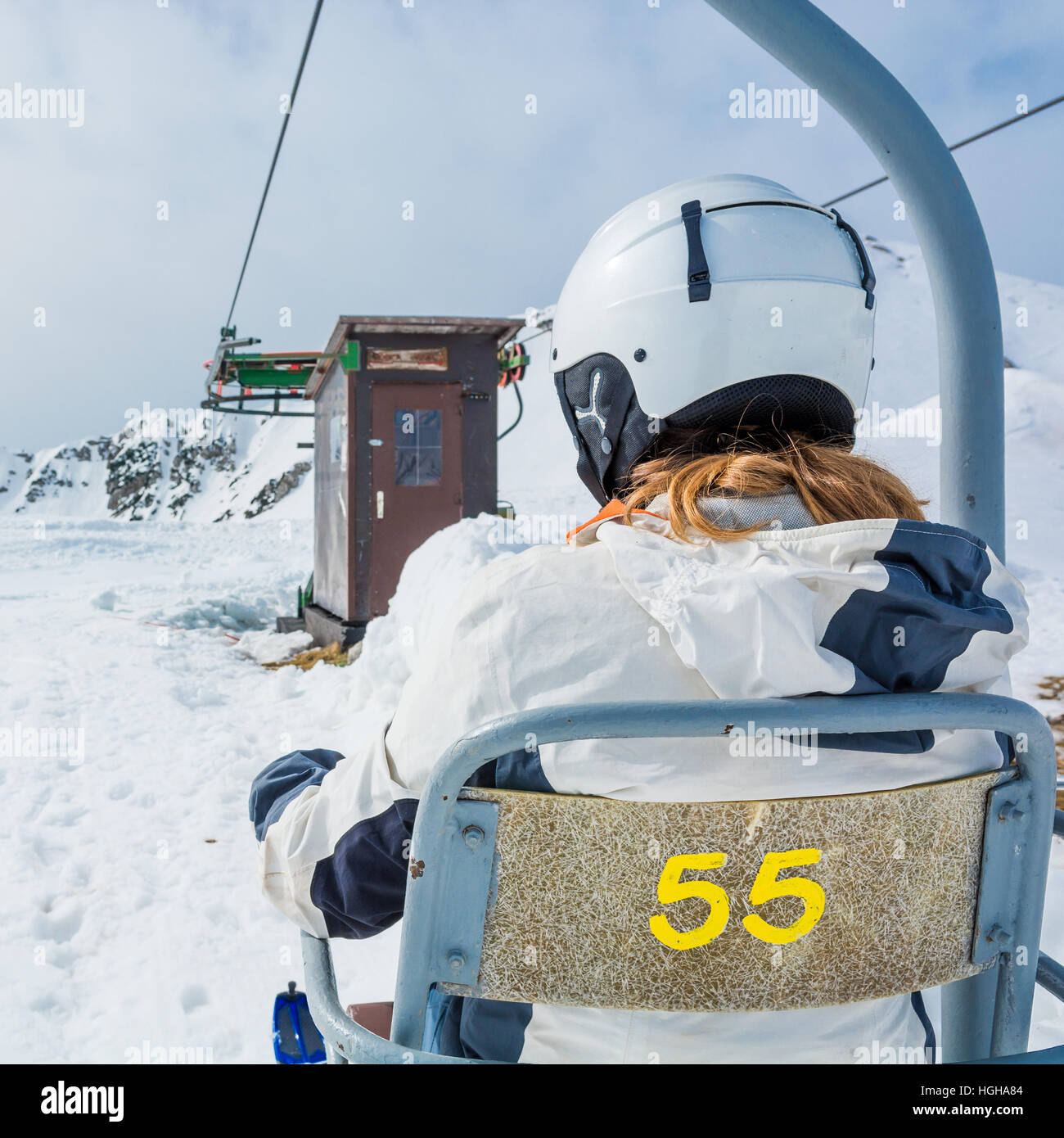 Back view of skier riding a lift Stock Photo - Alamy