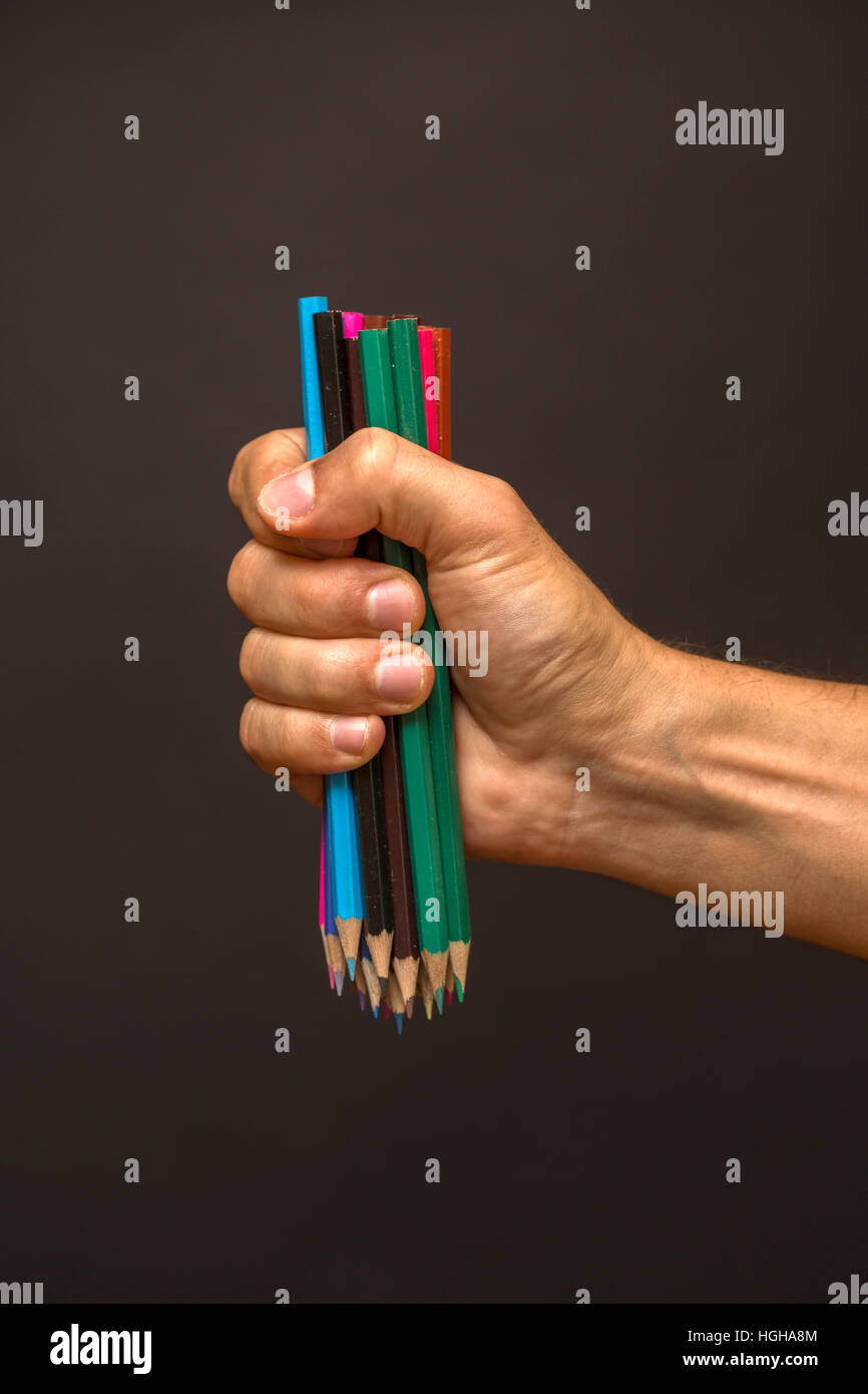 Hand with multicolored pencils isolated on black background Stock Photo ...