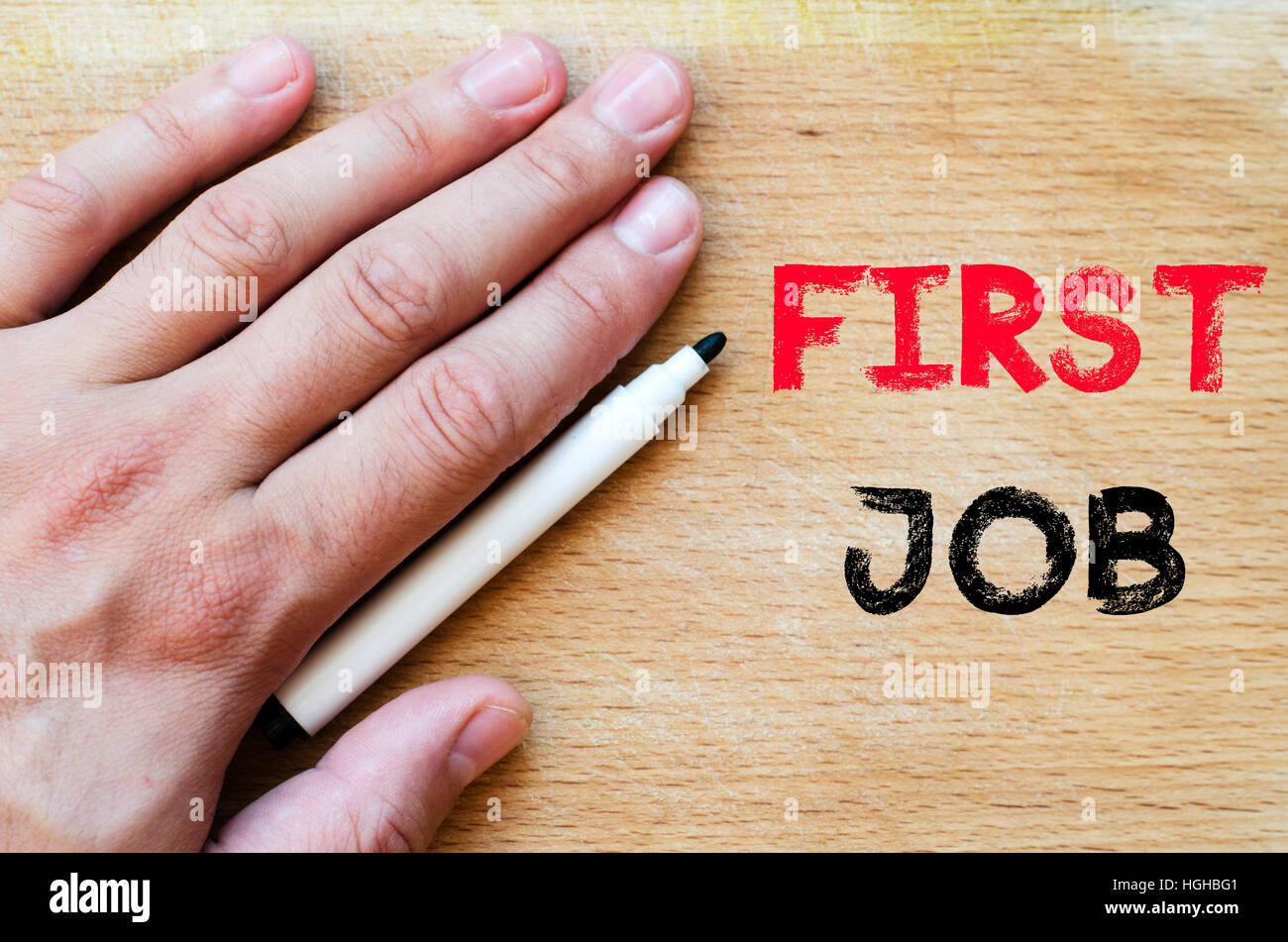 Human hand over wooden background and first job text concept Stock ...