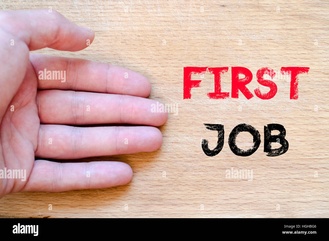 Human hand over wooden background and first job text concept Stock ...
