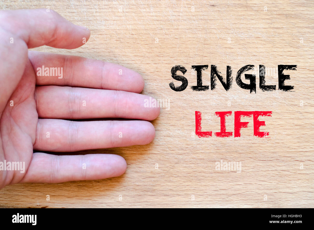 Human hand over wooden background and single life text concept Stock ...