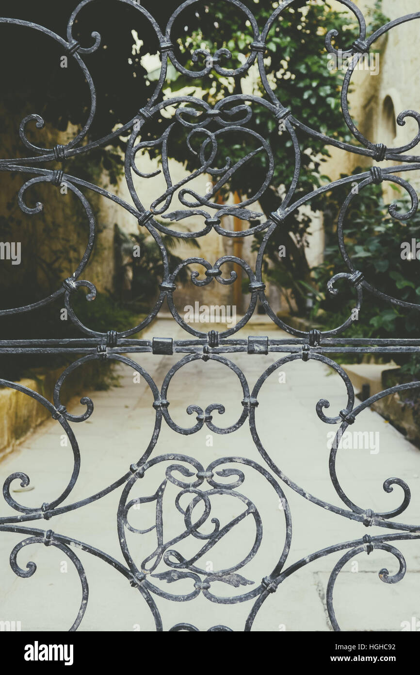 Part of iron gate closed with path leading up to house Stock Photo - Alamy