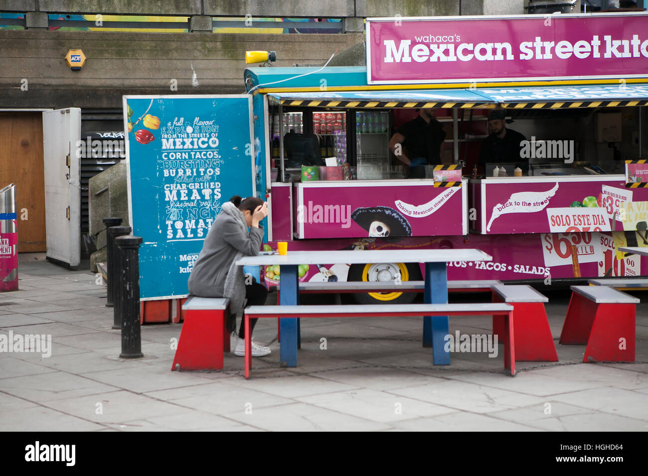 LONDON - October 27, 2016: Sad woman holding her head, sitting at an ...