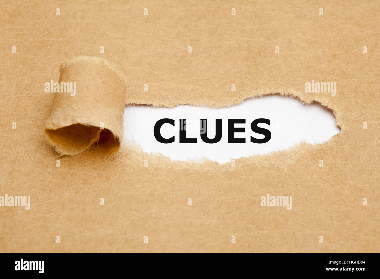 The word Clues appearing behind ripped brown paper Stock Photo - Alamy