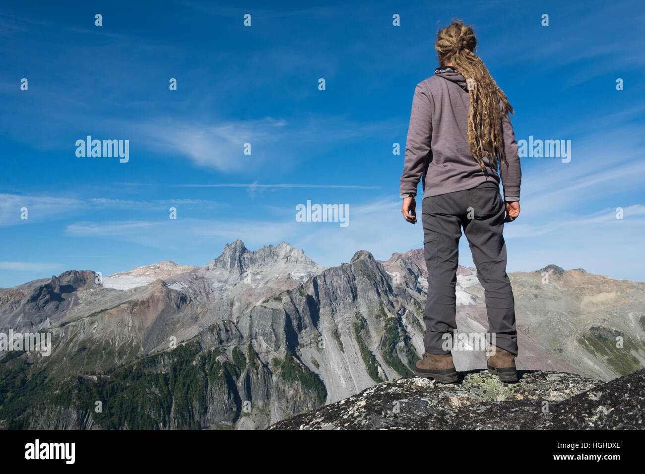A man looking out over alpine scenery from the top of a mountain near ...