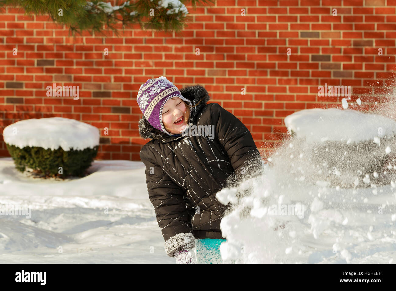 Little girl playing with snow little girl playing in the street with ...
