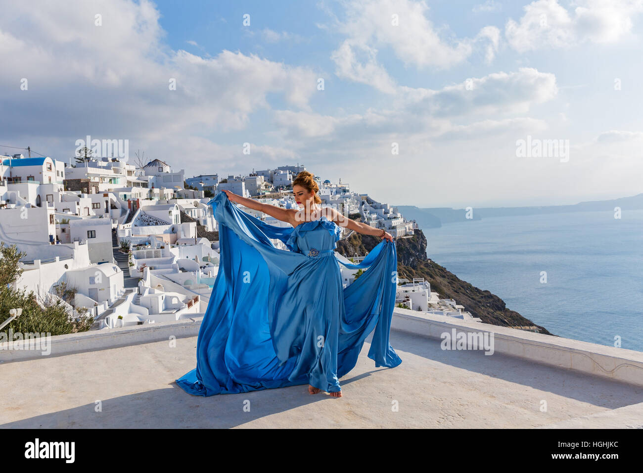 Woman in a beautiful blue dress with a long train on the island of ...